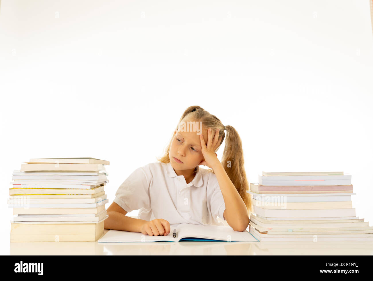 Sad and tired cute schoolgirl with blond hair sitting in stress doing ...