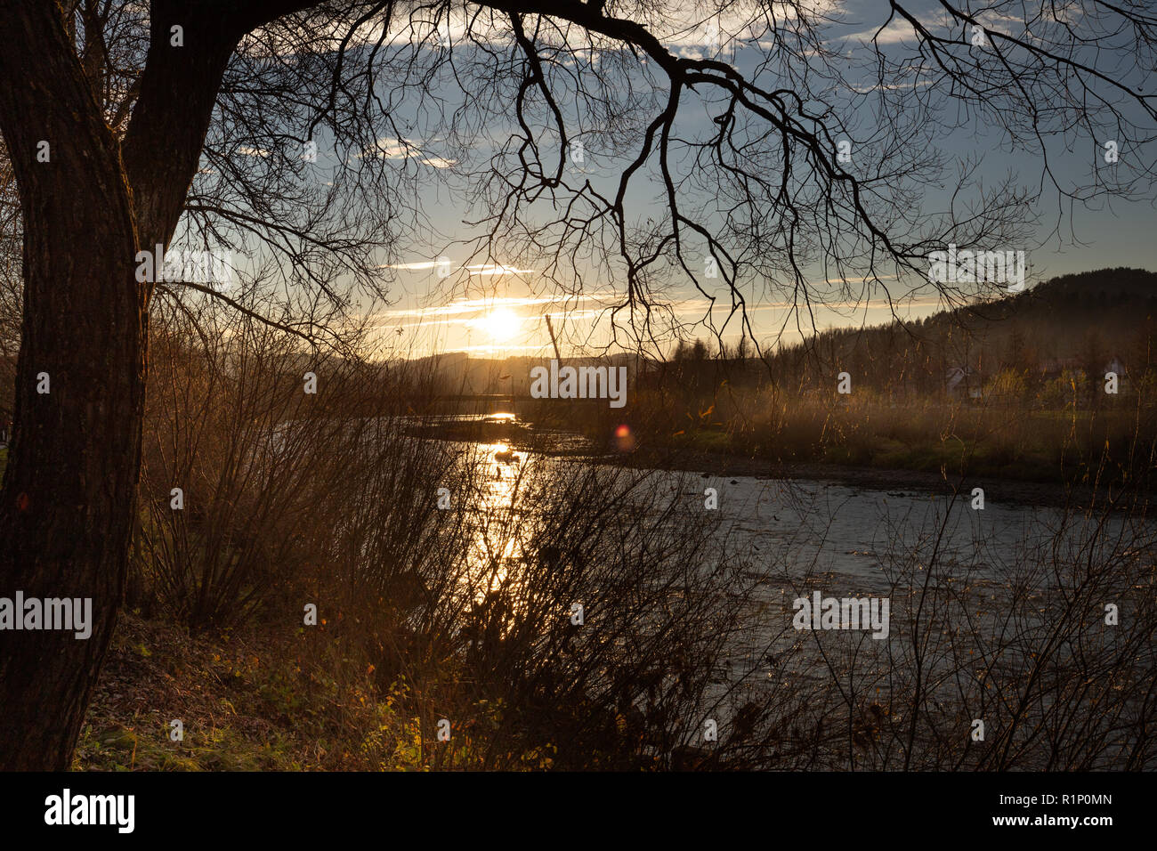 the sun setting over the river Stock Photo - Alamy