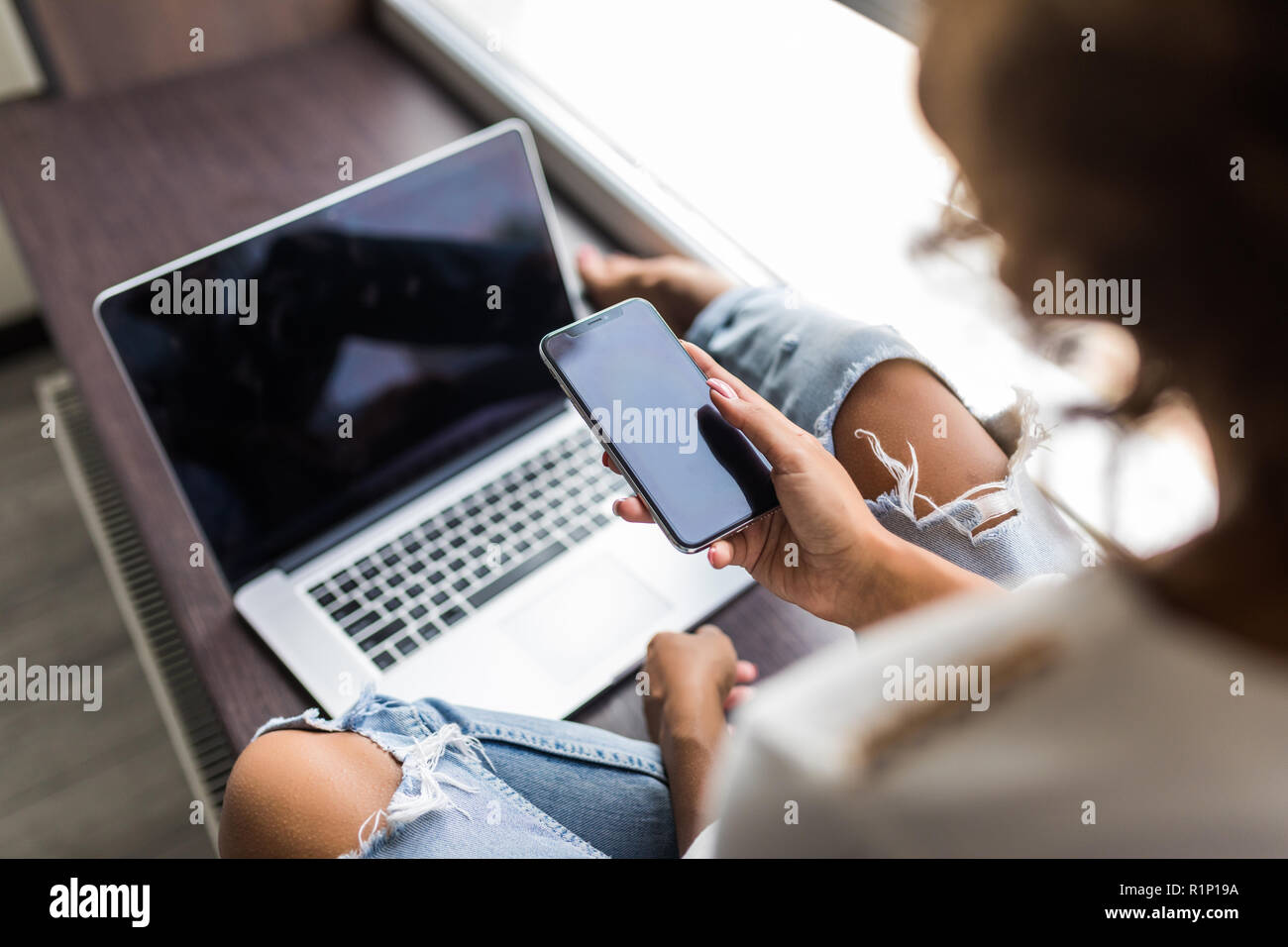 Hand use phone and laptop at home from above Stock Photo - Alamy