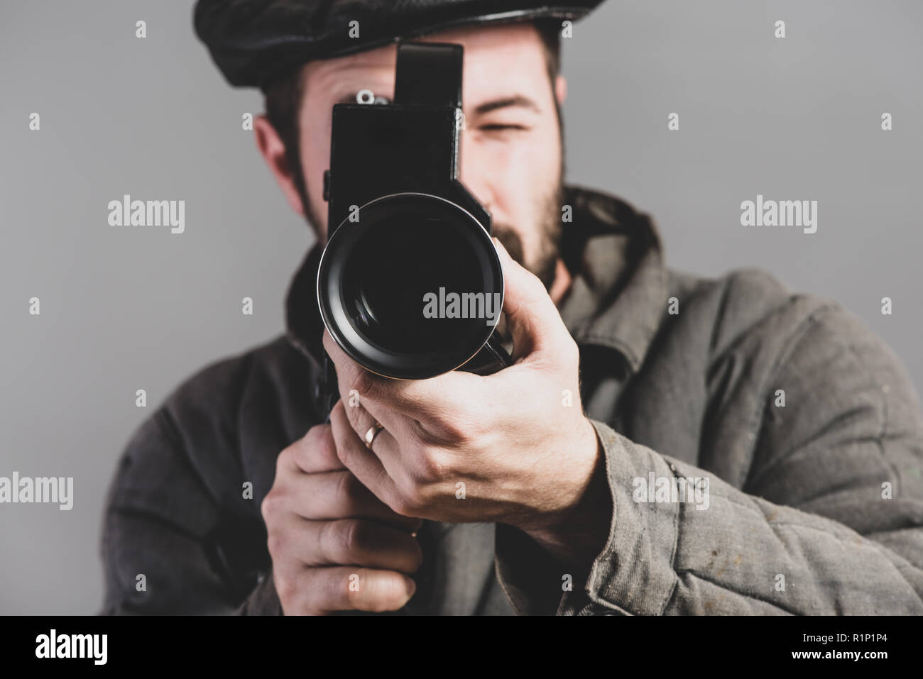 Cameraman with a retro camera in his hands, studio shot, close up. Old ...