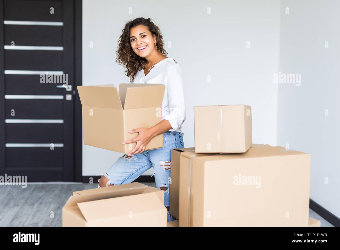 Happy smiling woman carrying carton boxes moving Stock Photo - Alamy