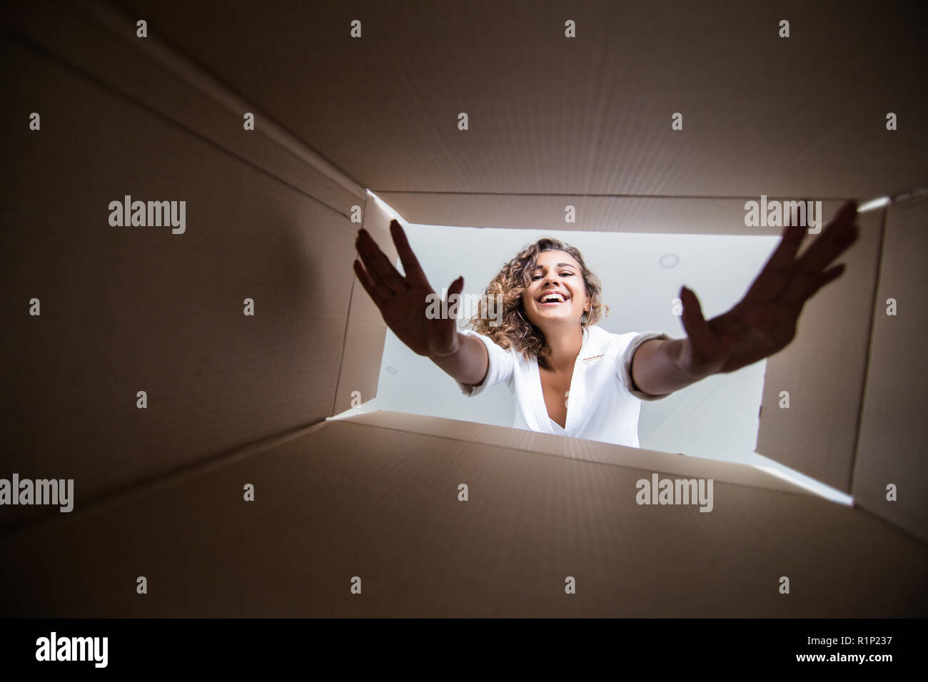 The surprised woman opening box and looking inside. The package ...