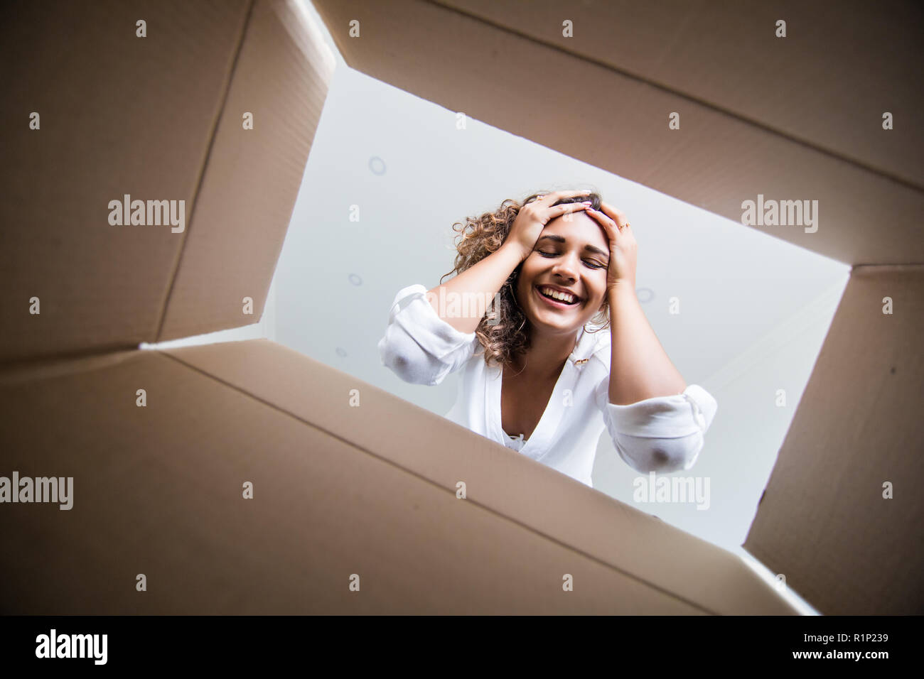 The surprised woman opening box and looking inside. The package ...