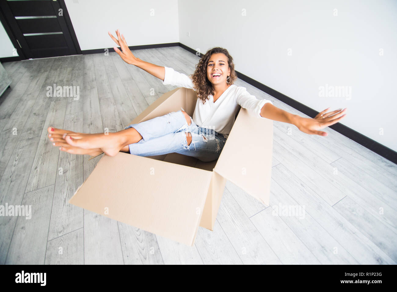 Cheerful woman sitting in a cardboard box Stock Photo - Alamy