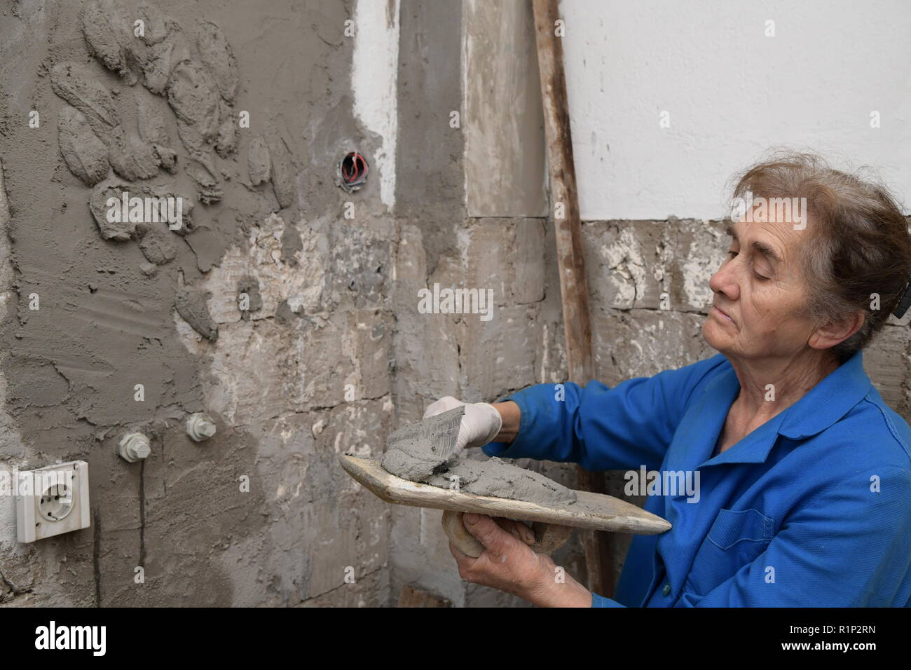 Woman worker plastering concrete at wall of house construction Stock ...
