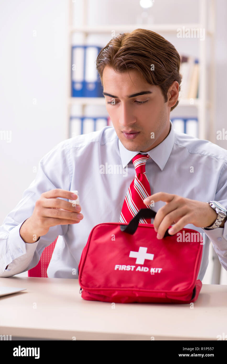 Man with first aid kit in the office Stock Photo - Alamy