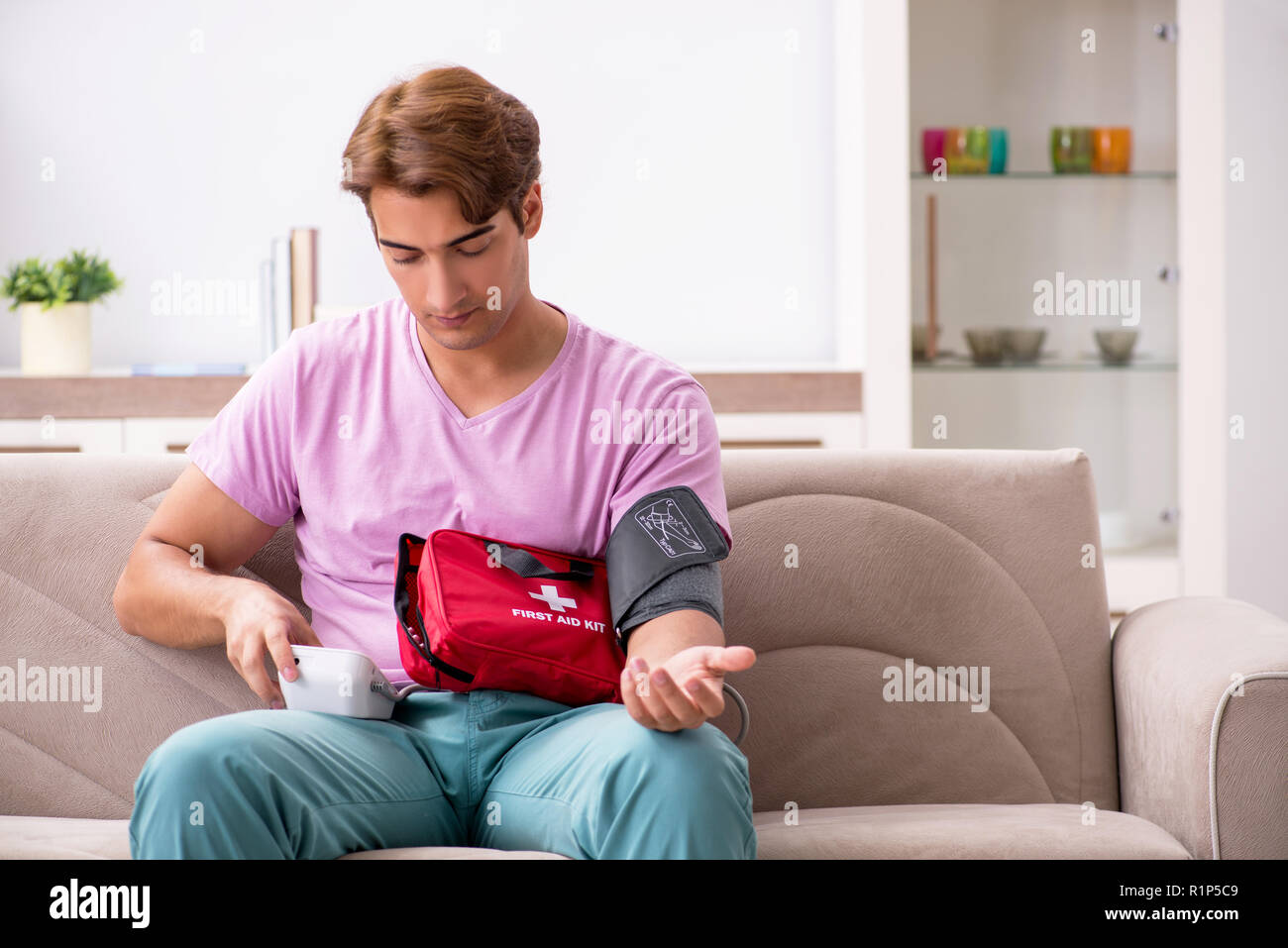 Sick man at home with first aid kit Stock Photo - Alamy