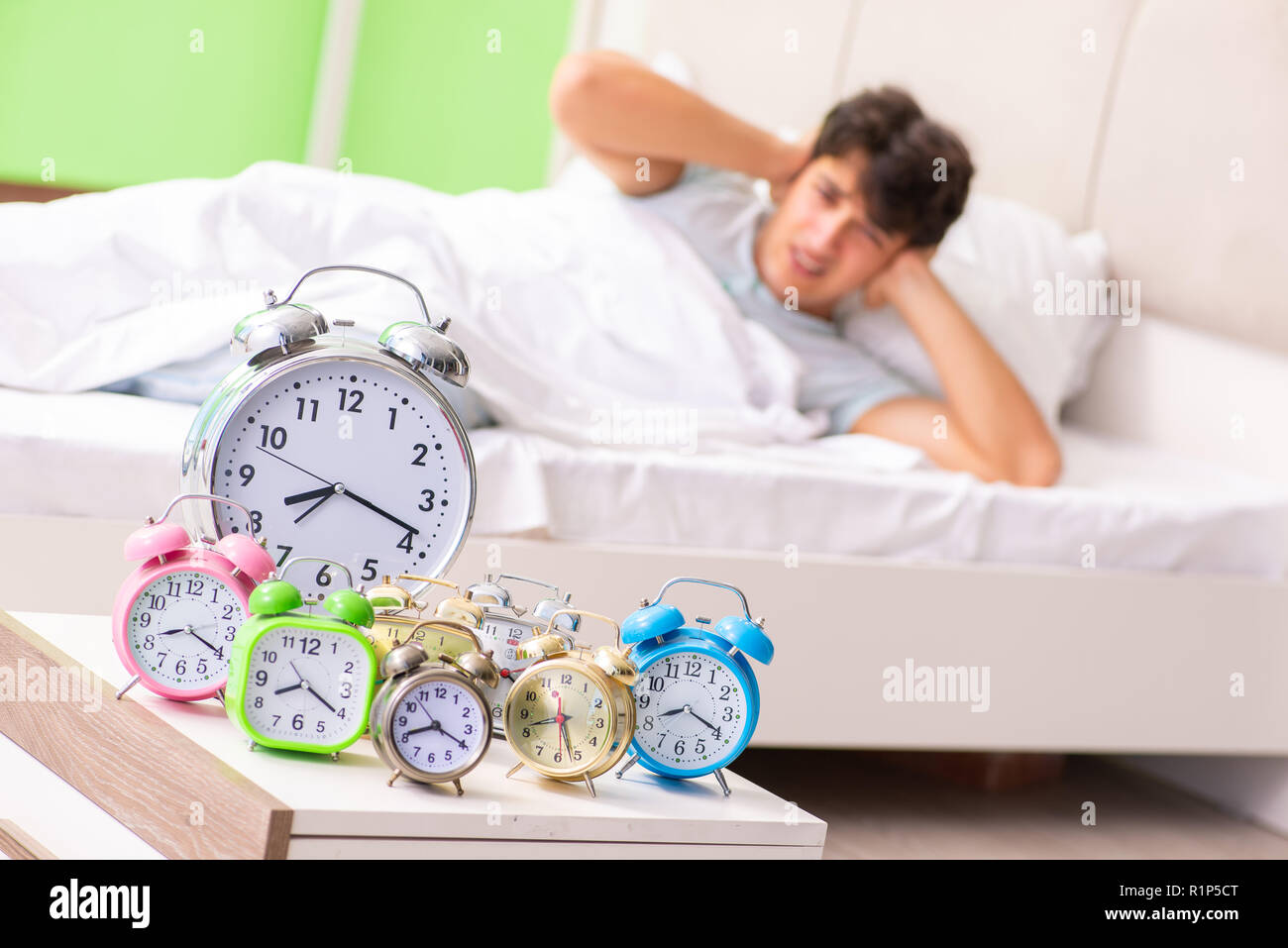 Young man having trouble waking up in early morning Stock Photo - Alamy