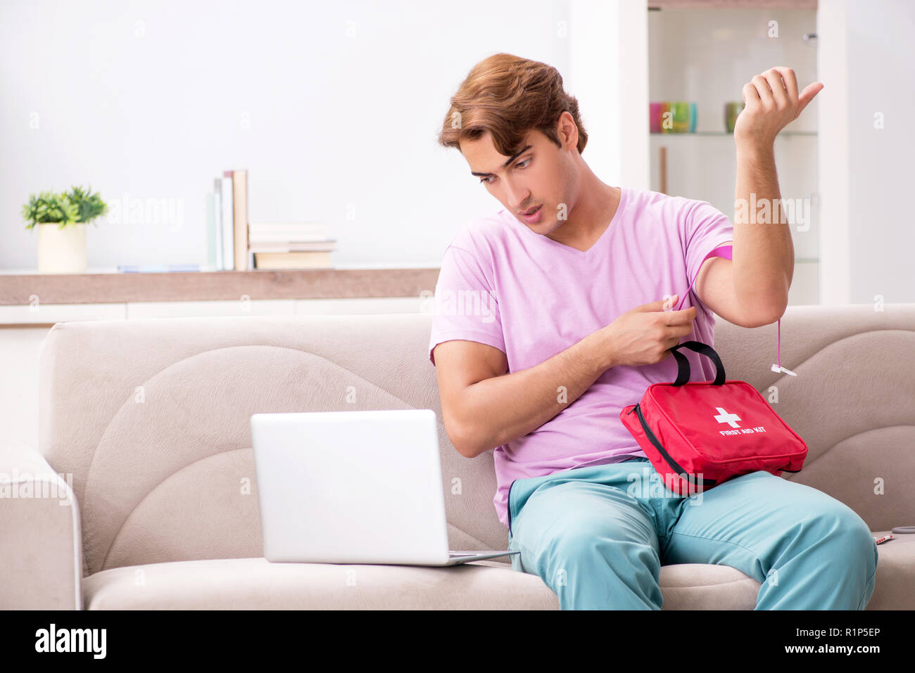 Sick man at home with first aid kit Stock Photo - Alamy