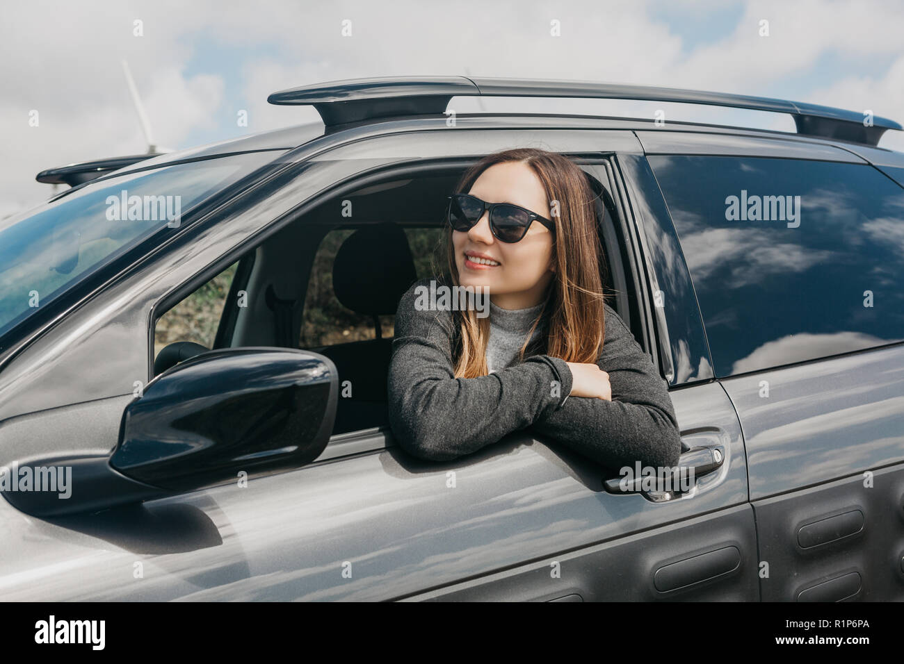 Portrait of a young smiling joyful woman or girl driver inside the car ...