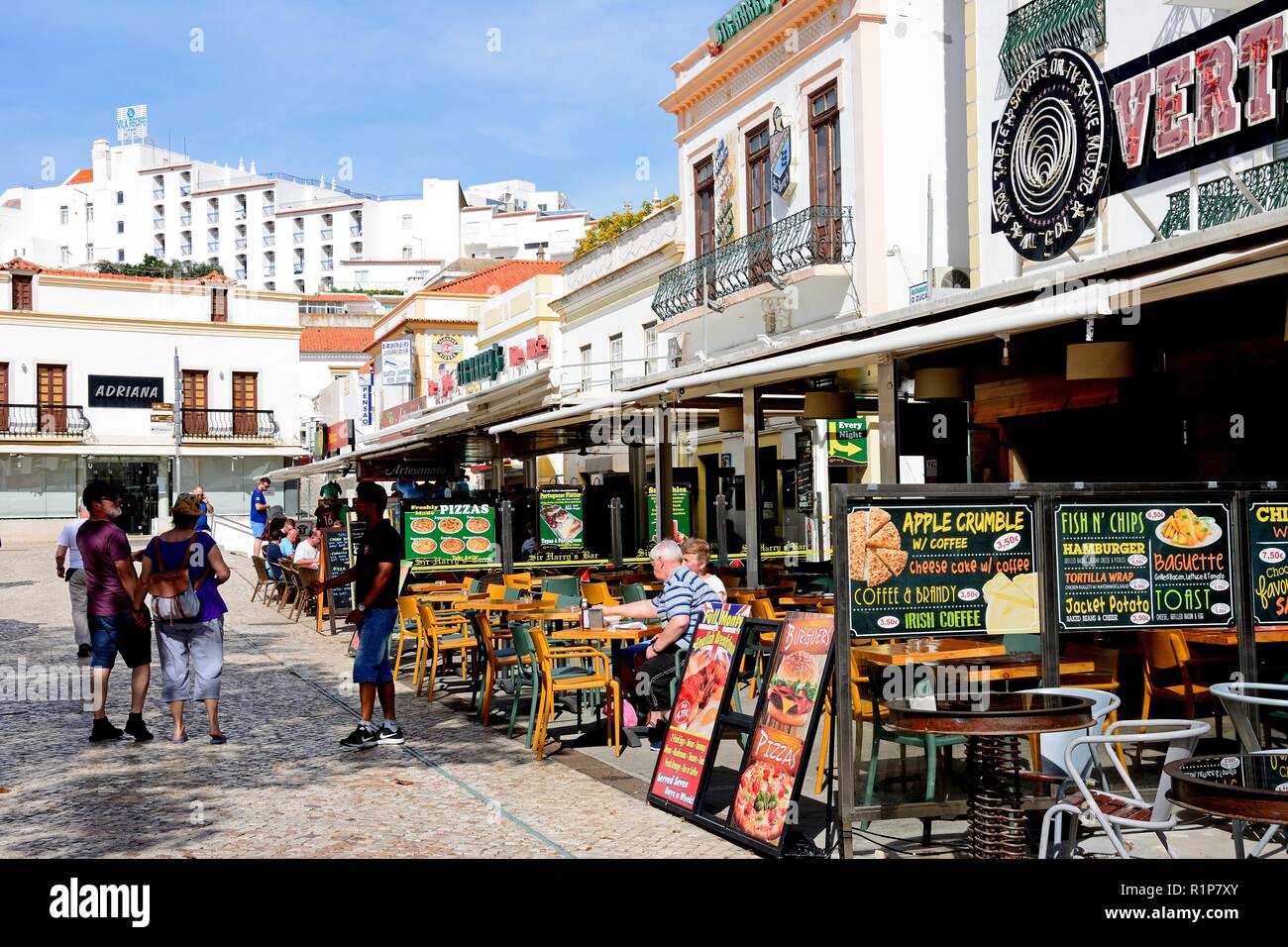 Tourists relaxing at pavement cafes in the main square in the old town ...