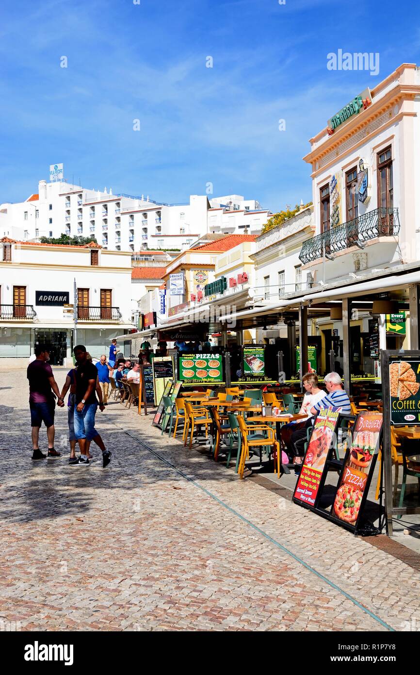 Tourists relaxing at pavement cafes in the main square in the old town ...