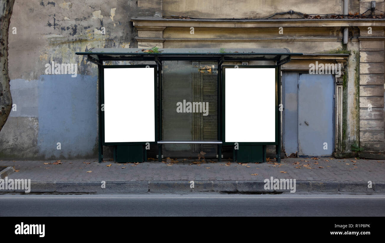Two vertical blank white billboards at bus stop on old city street. In ...