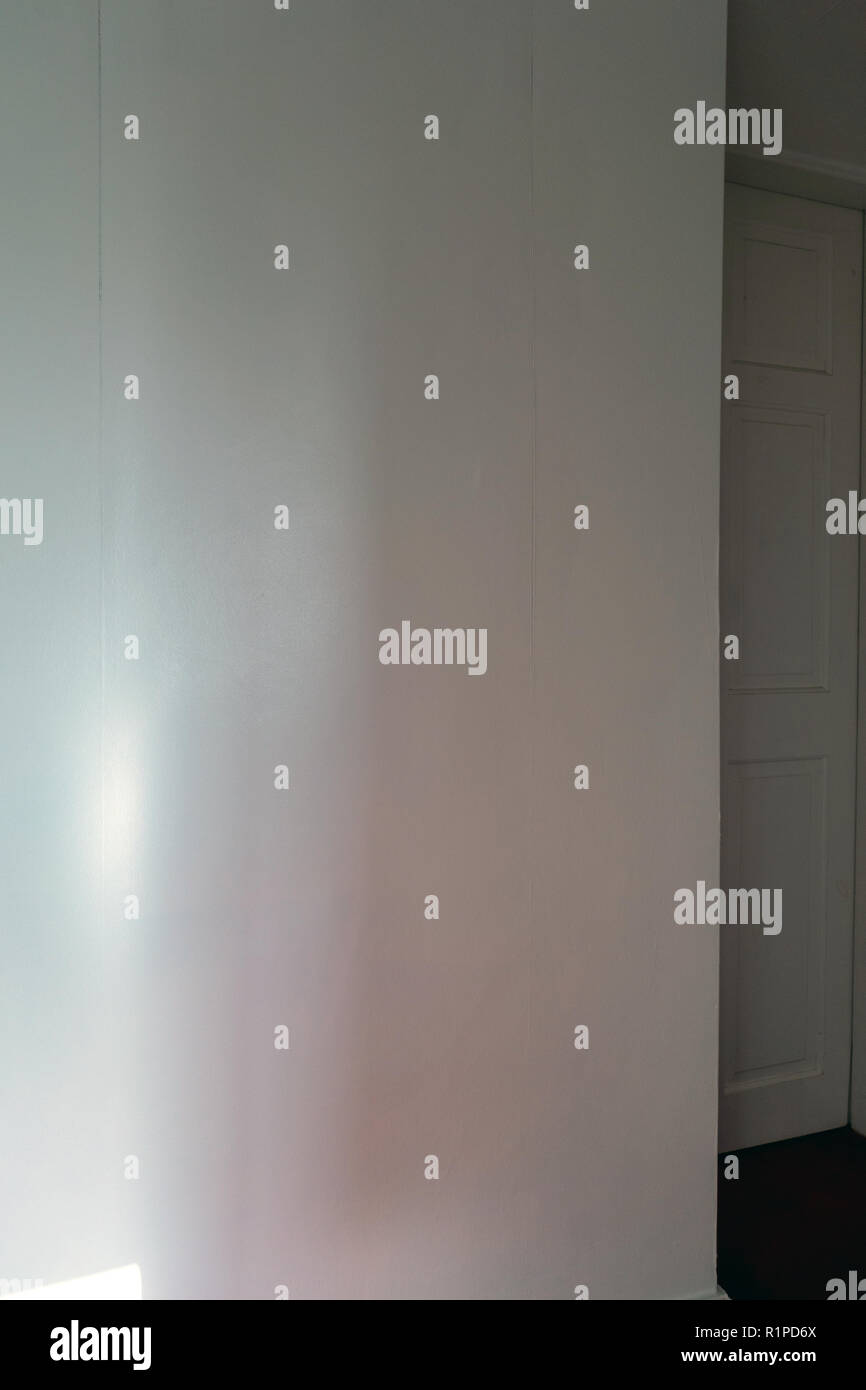 simple sheets of plain wallpaper on wall with join showing near a ...