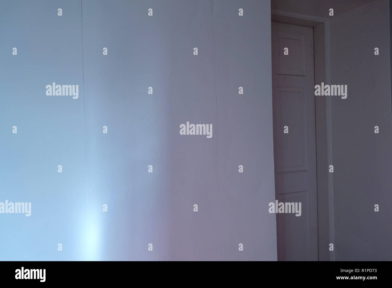 simple sheets of plain wallpaper on wall with join showing near a ...