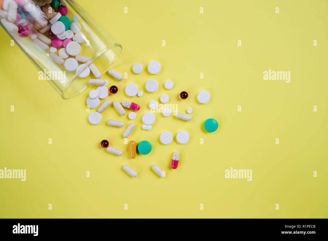 Large and bright red and white, colorful pills are scattered from a ...