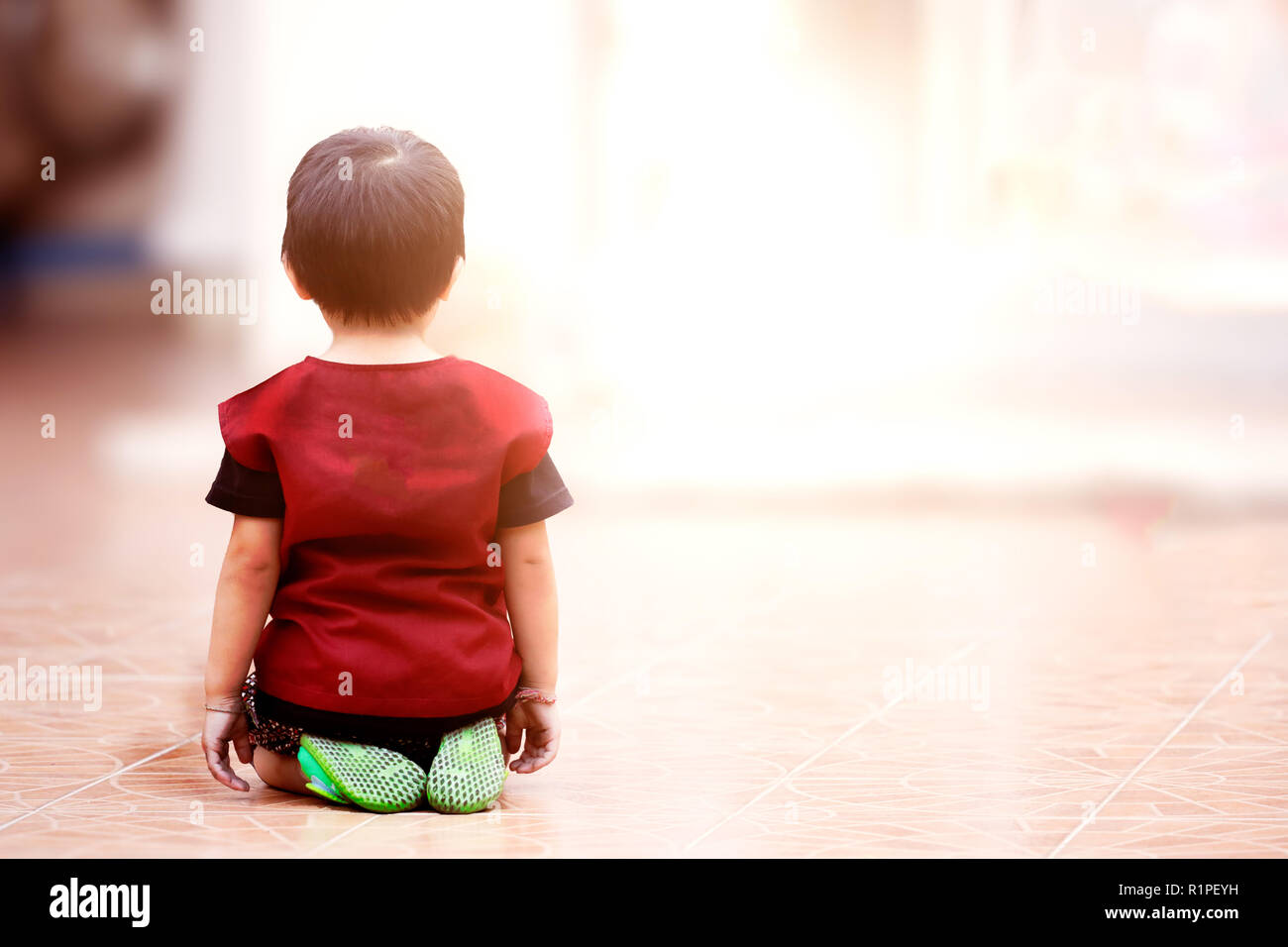 Hope kid boy sitting looking to the light Stock Photo - Alamy