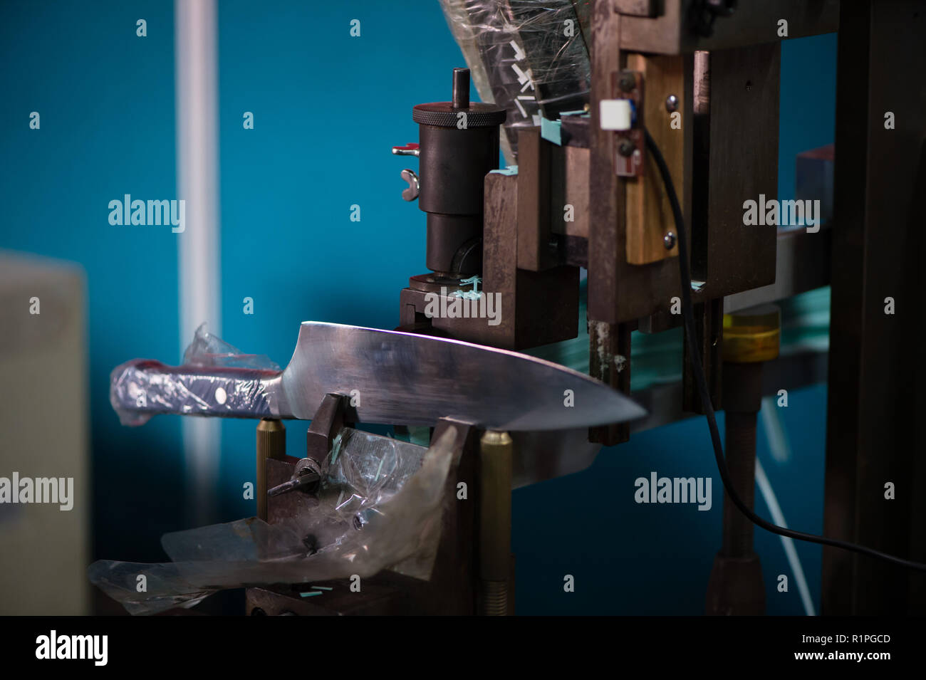 Knife blade making test cut with paper on machinery, manufacturing ...