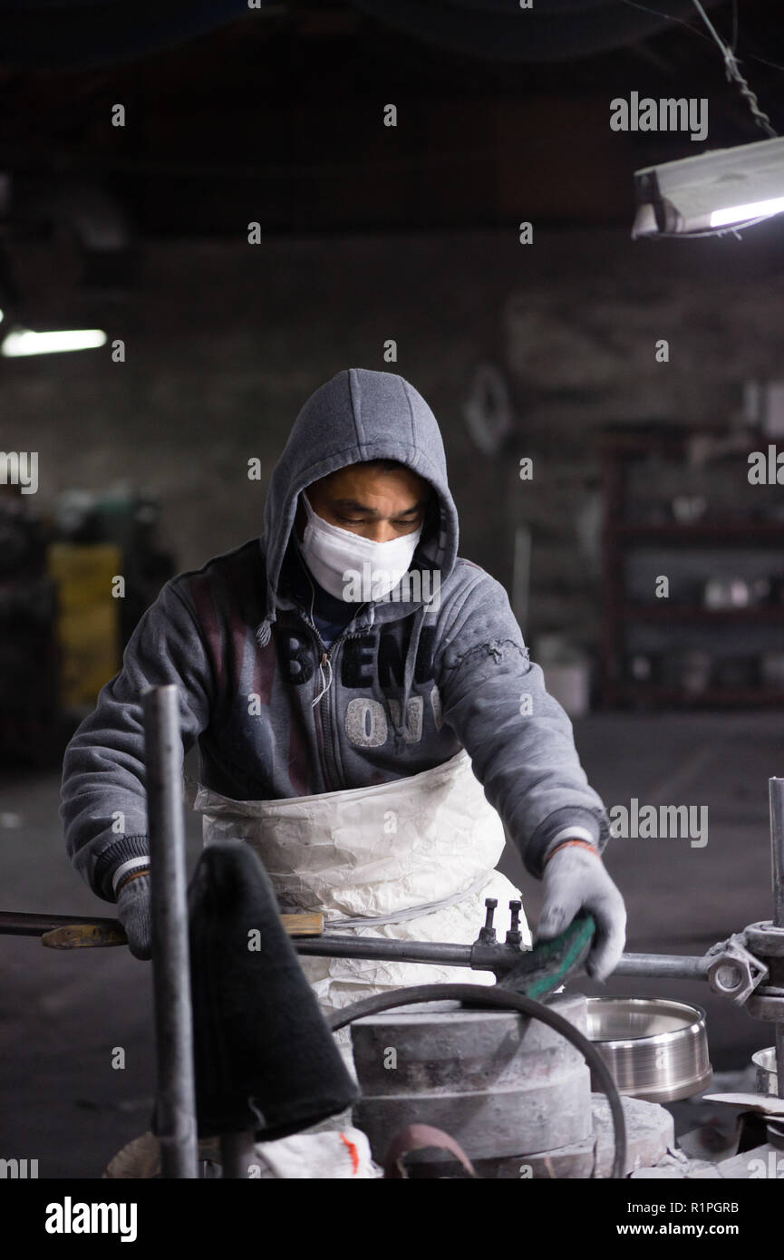 Masked factory worker in workshop setting Asia manufacturing production ...