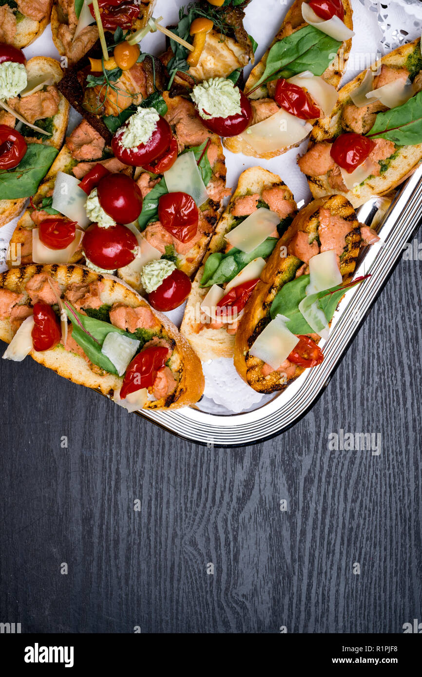 background of small canapes laying on metal tray. Appetizers with ...