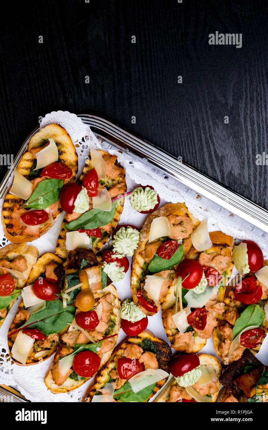 background of small canapes laying on metal tray. Appetizers with ...