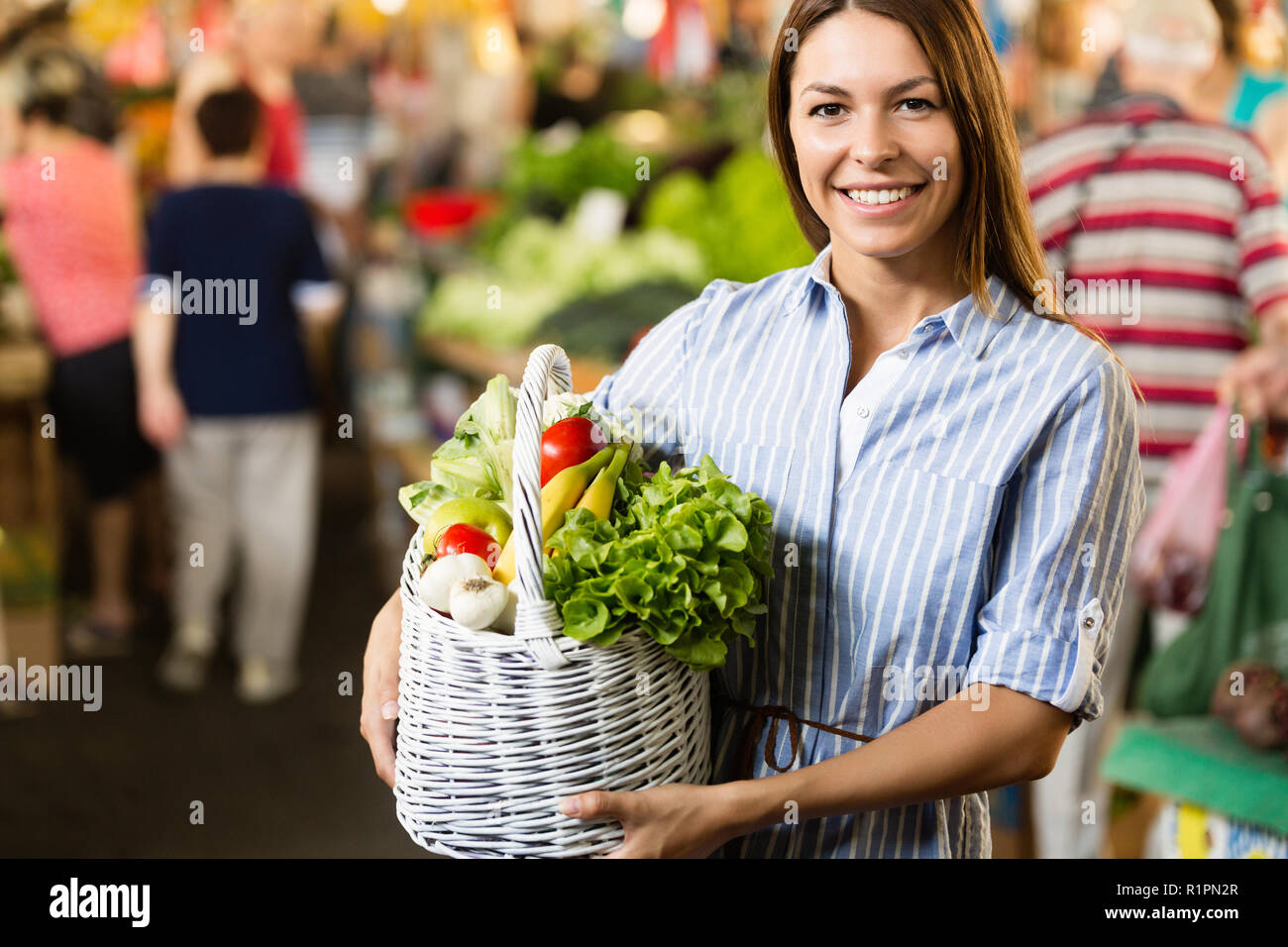 Beautiful young brunette woman on a market getting food Stock Photo - Alamy