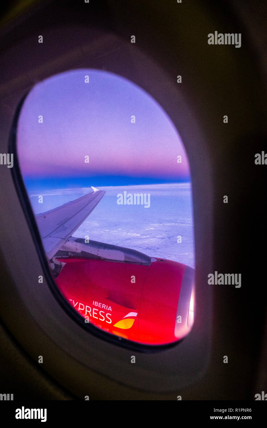 Airplane window looking out over the wing and engine on an Iberia ...