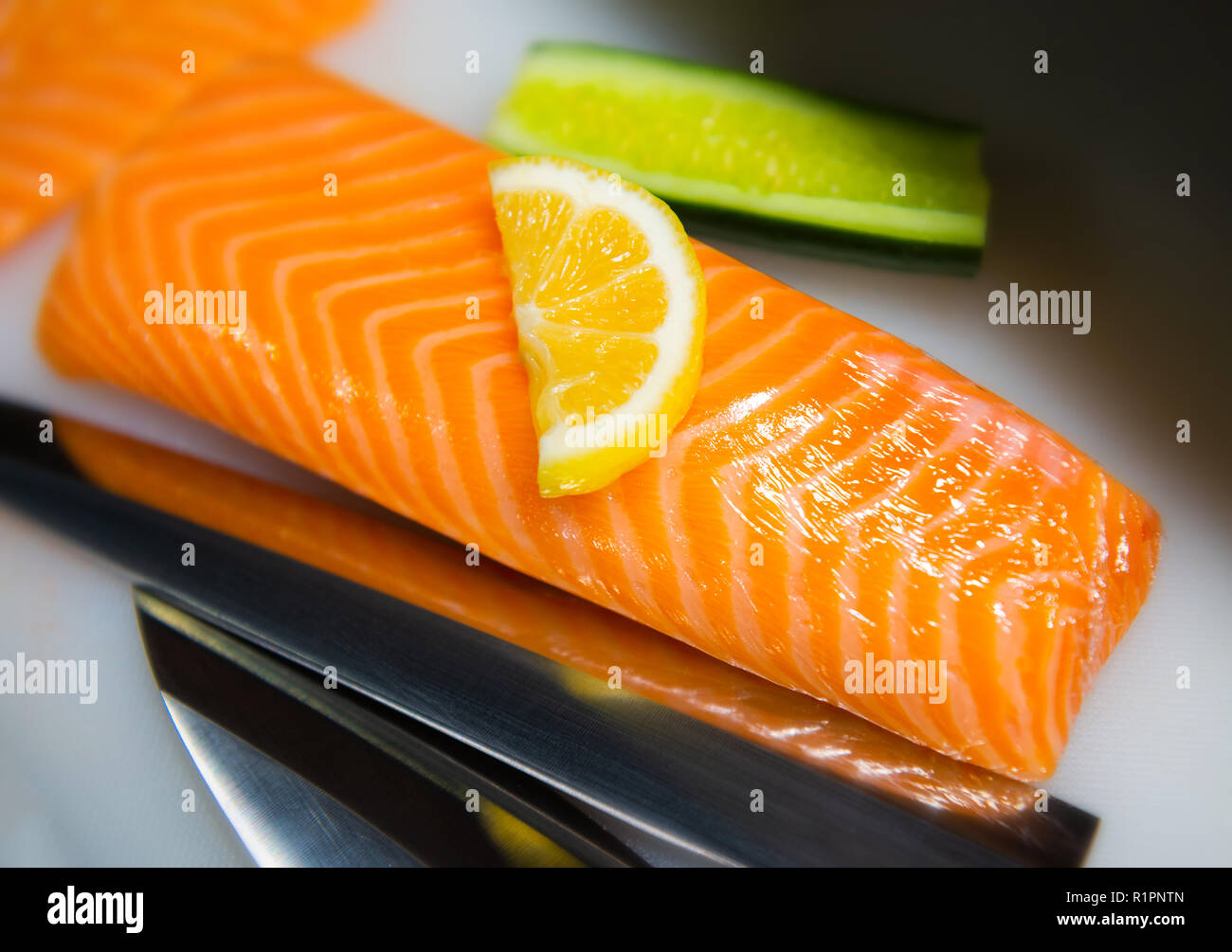 Salmon cutting preparing for cooking in the kitchen with another ...