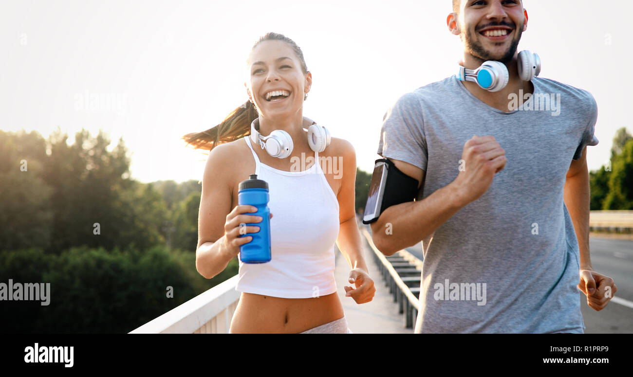 Athletic young cute couple jogging together outdoors Stock Photo - Alamy