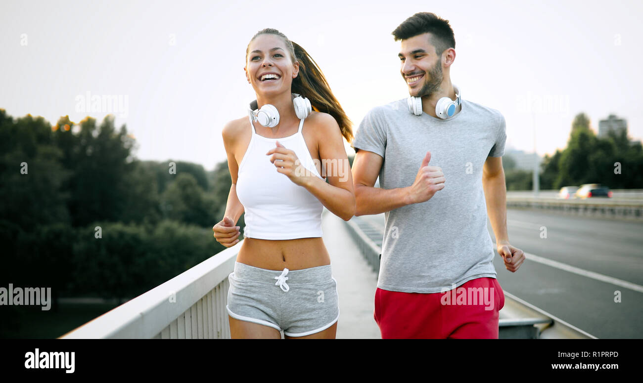 Athletic young cute couple jogging together outdoors Stock Photo - Alamy