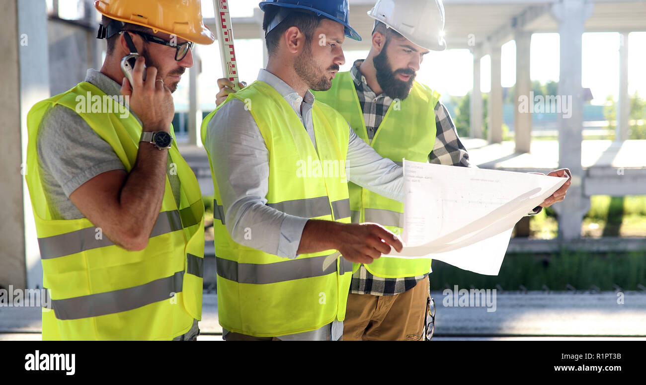Team of construction engineers working on building site Stock Photo - Alamy