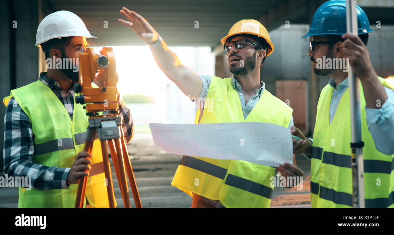 Team of construction engineers working on building site Stock Photo - Alamy