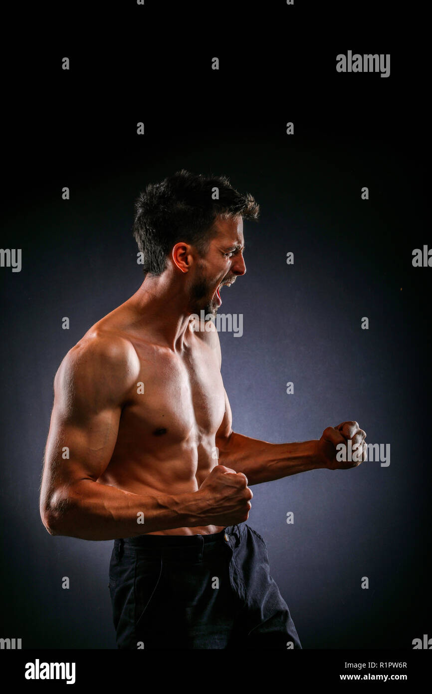 Strong athletic muscular man feeling victory and enjoys success in low ...