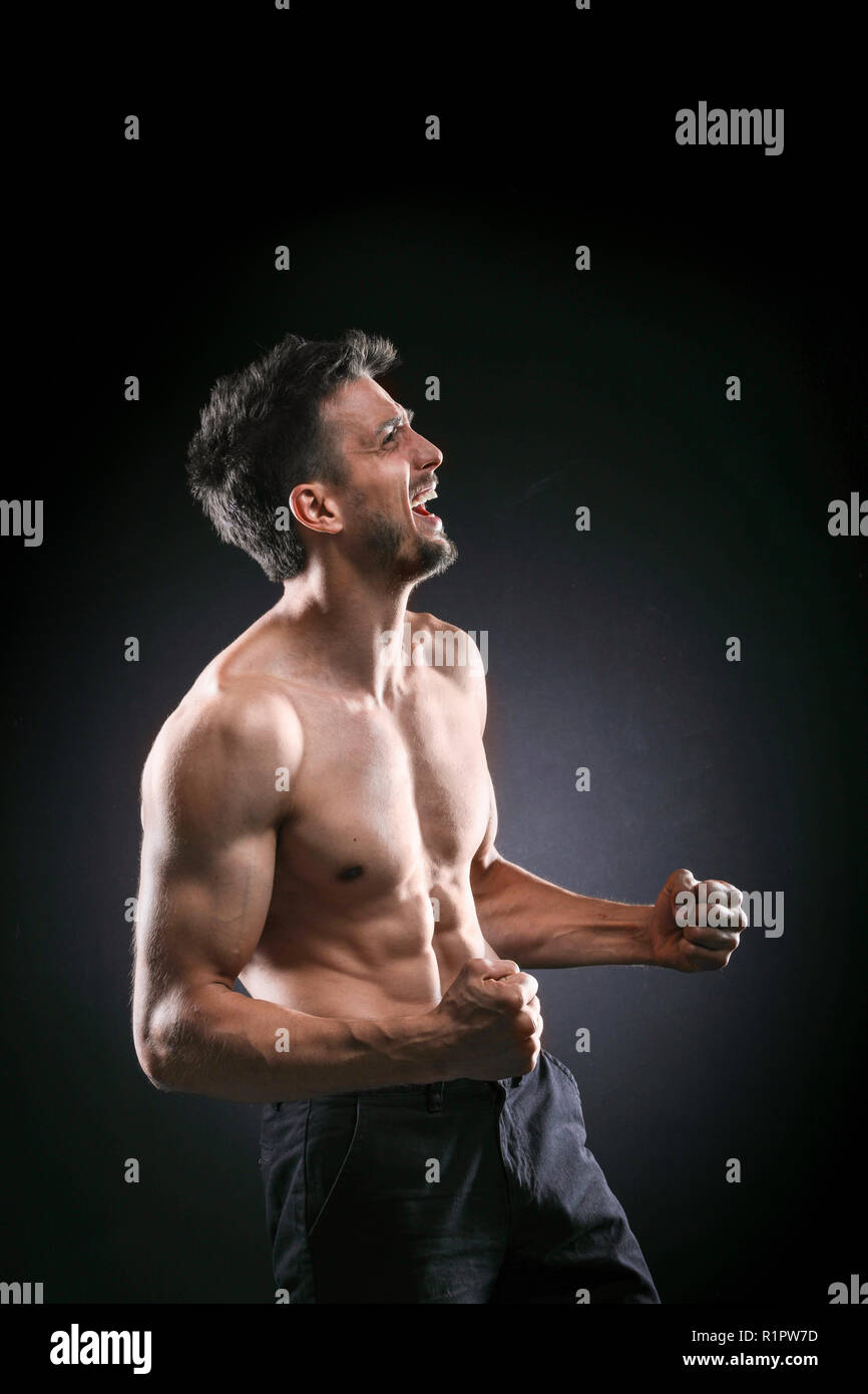 Strong athletic muscular man feeling victory and enjoys success in low ...