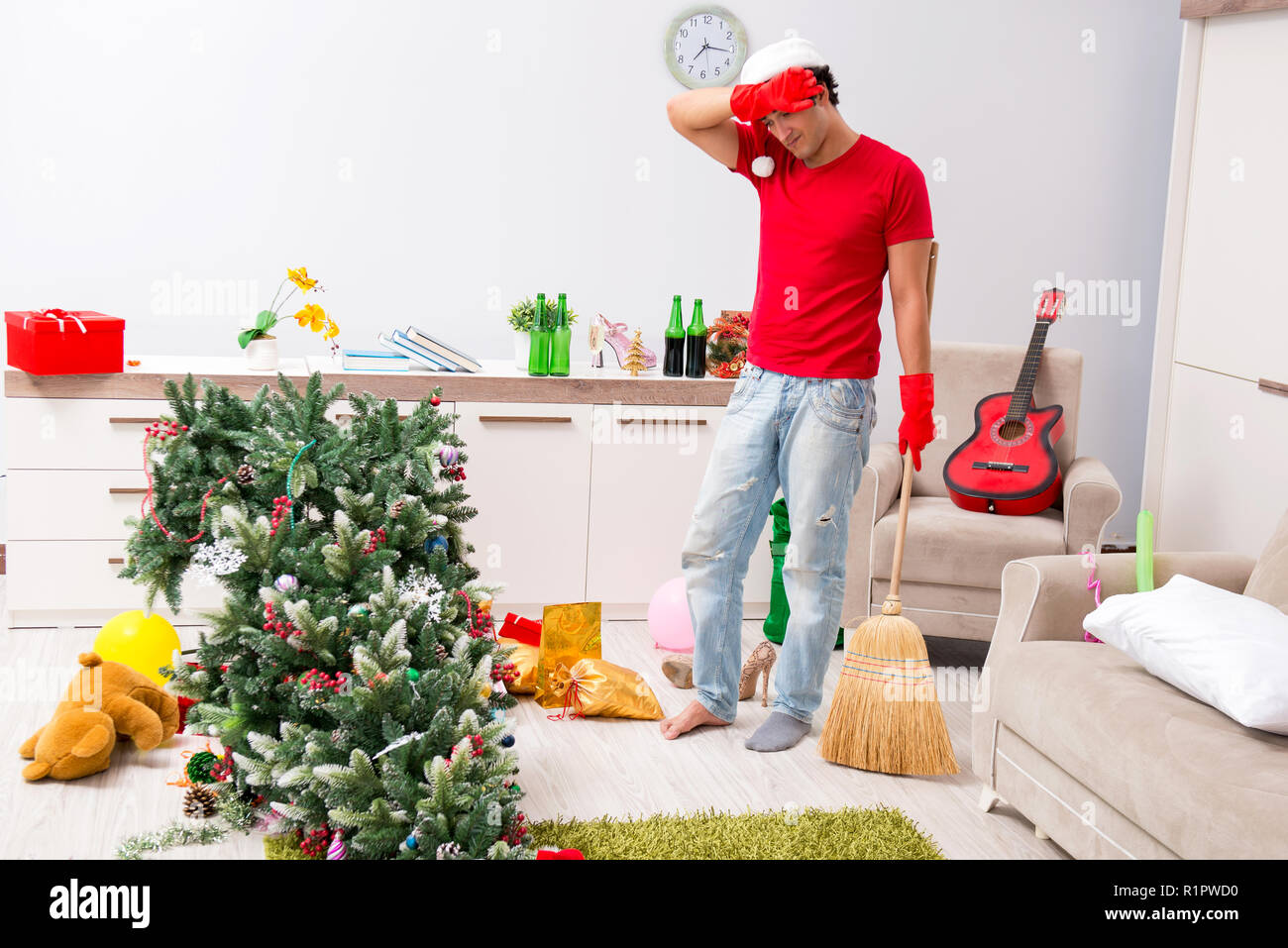 Man cleaning his apartment after christmas party Stock Photo - Alamy