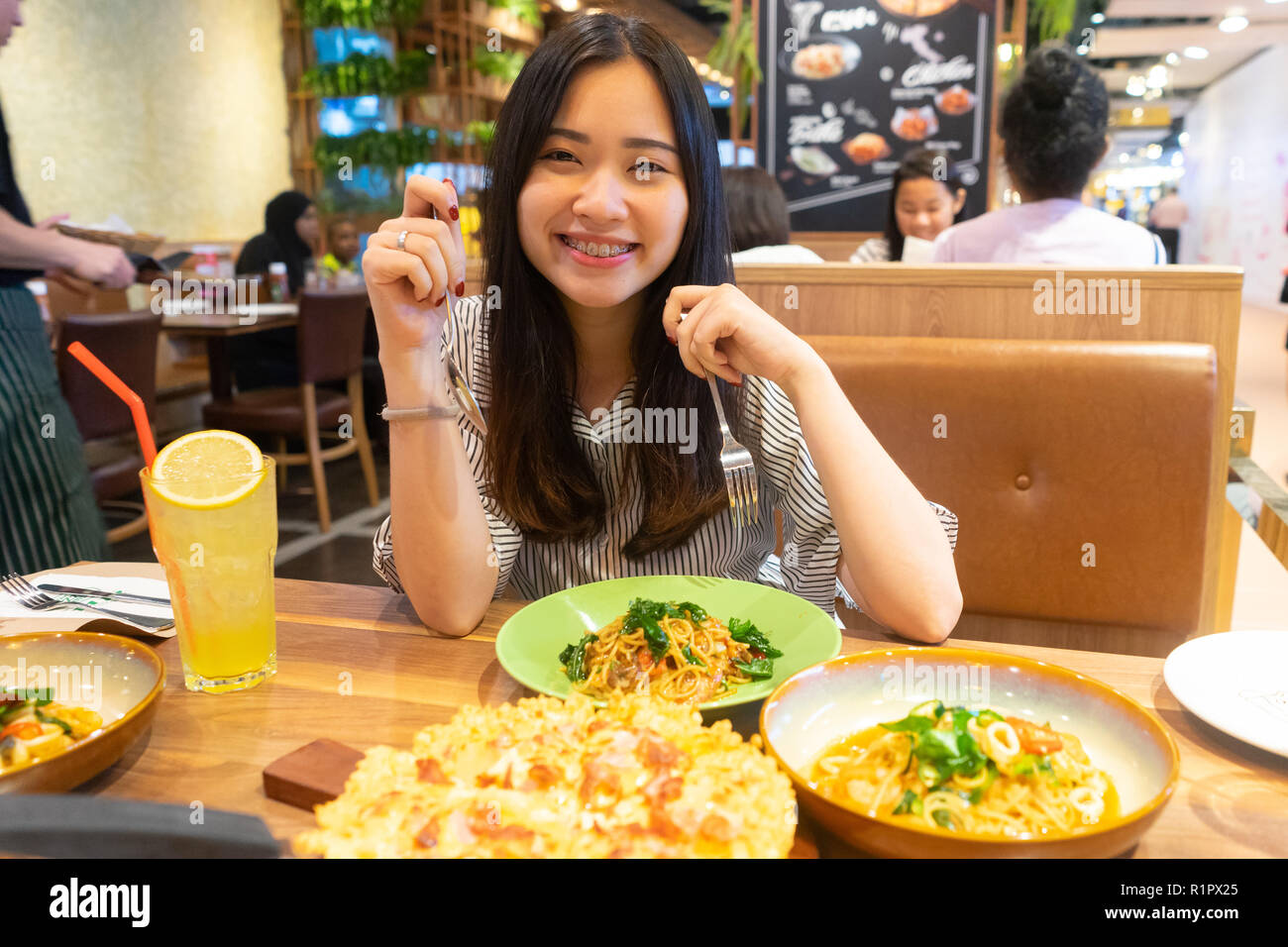 Asian girl eating delicious pizza hi-res stock photography and images ...