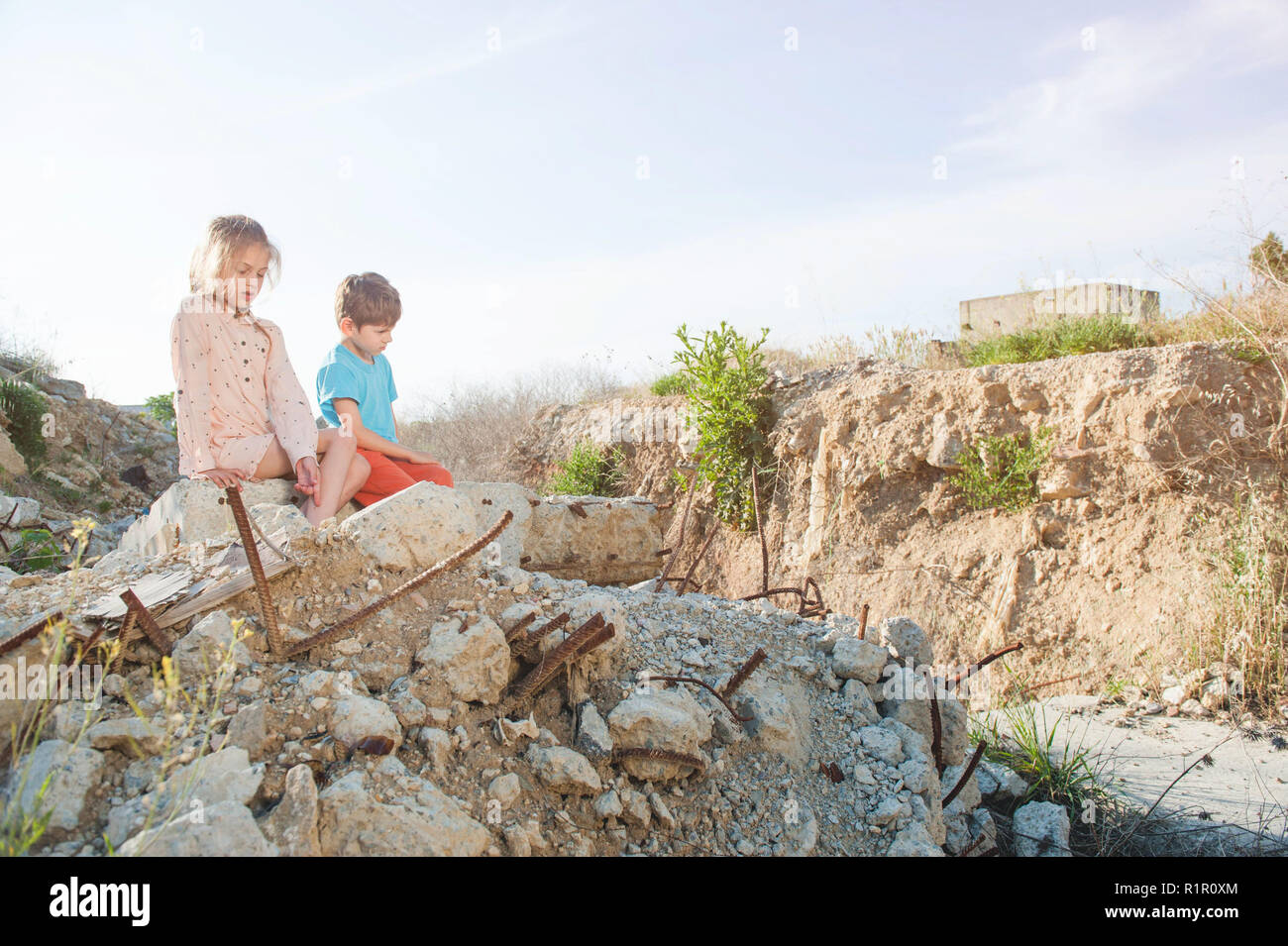 two poor refugee children boy girl on ruins building destroyed by air ...