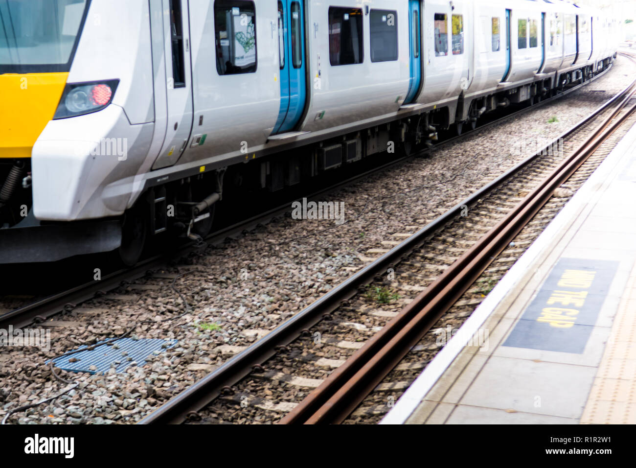 Train moving away from the platform at the rail station Stock Photo - Alamy