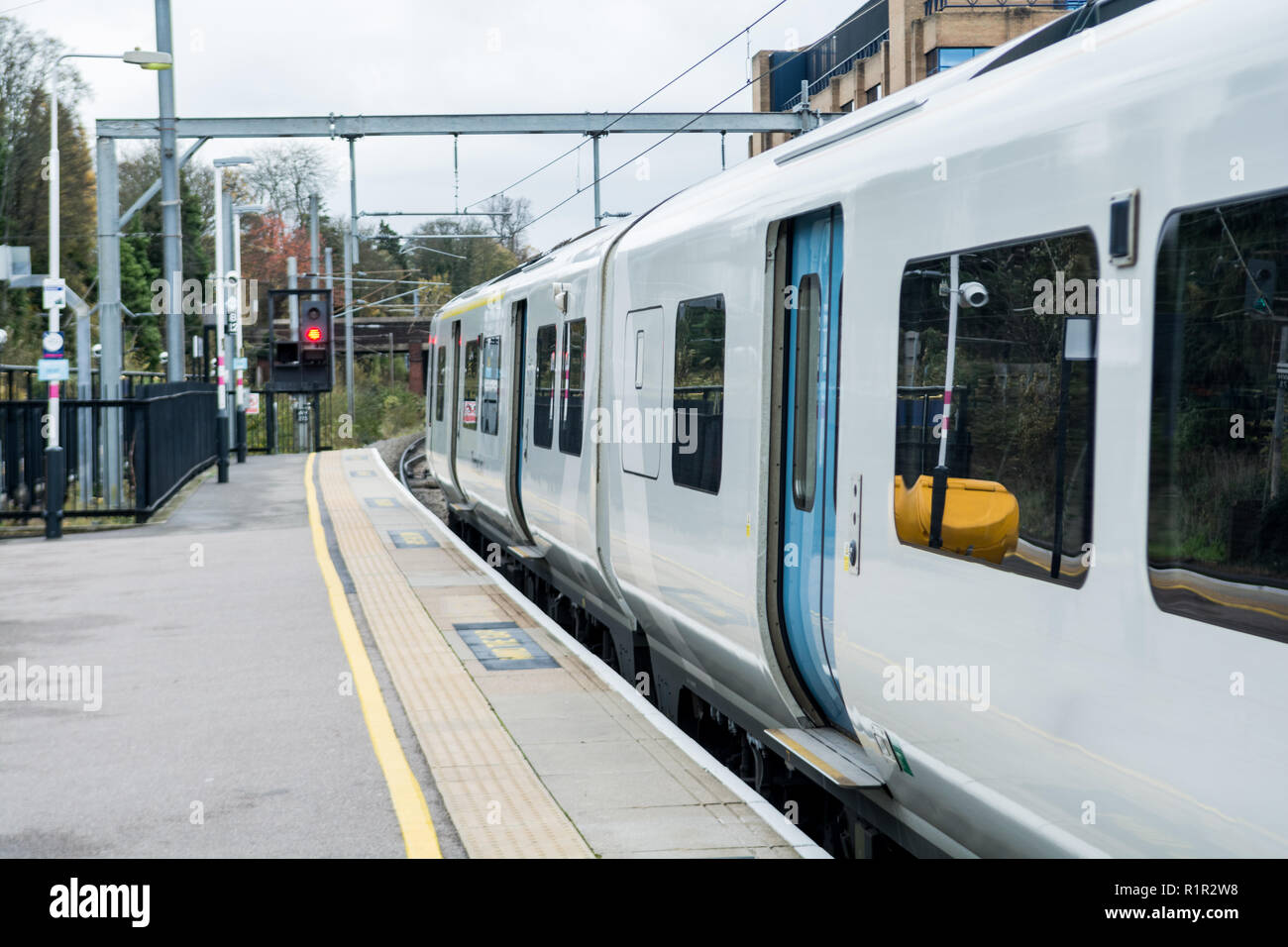 Train moving away from the platform at the rail station Stock Photo - Alamy