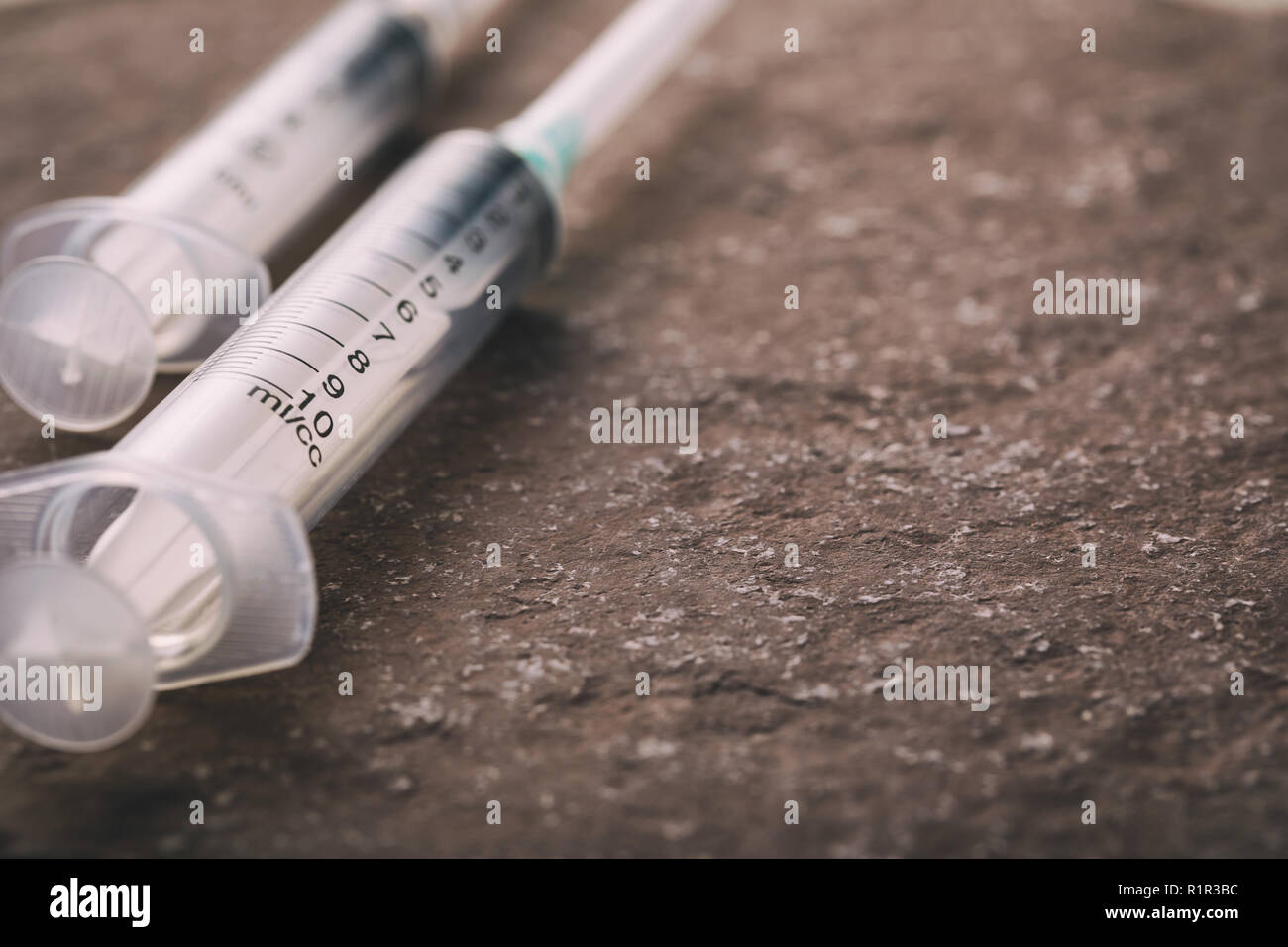 Empty syringes on a stone surface with copy space Stock Photo - Alamy