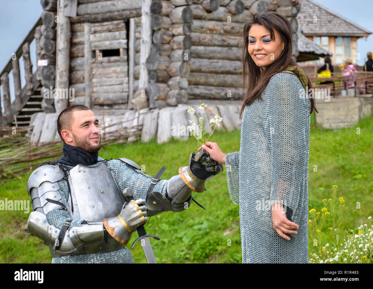 A knight in armor gives chamomile to his lady heart Stock Photo - Alamy