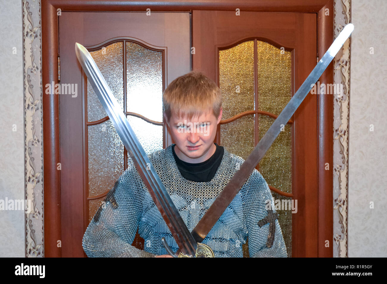 A man dressed up in a knight's hauberk at home in his room. Knight's ...