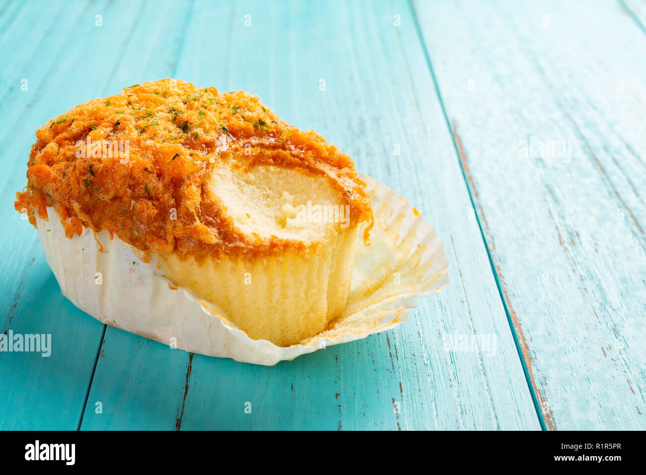side view shredded pork bread with a bite on blue wood background Stock ...