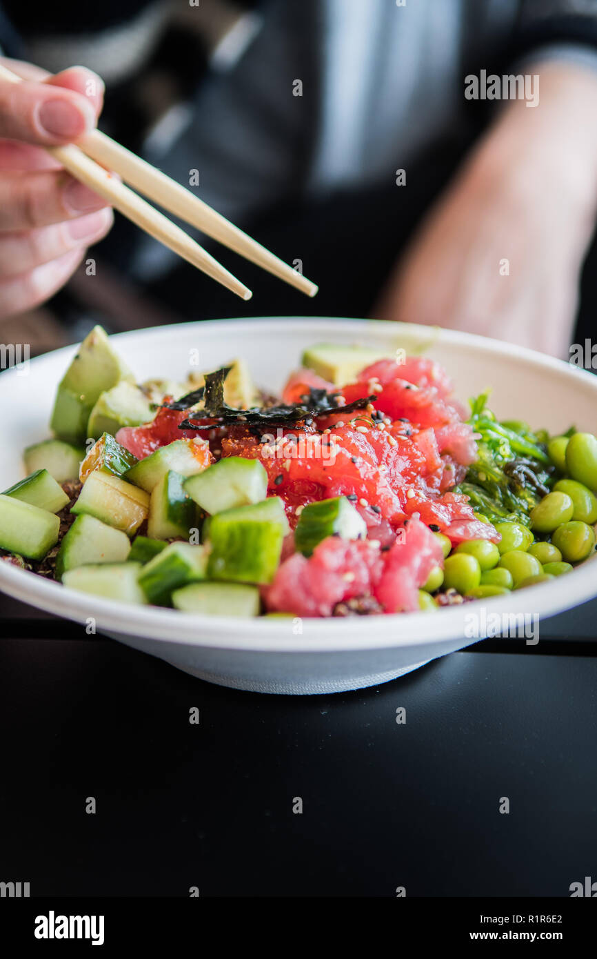 Woman eating hawaiian poke bowl Stock Photo - Alamy