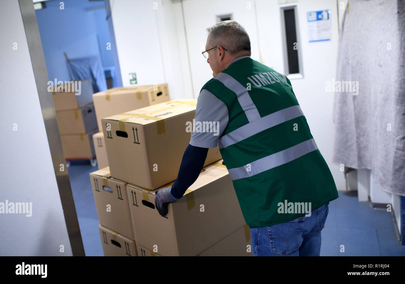 Pullach, Germany. 09th Nov, 2018. Removal helpers drive crates through ...