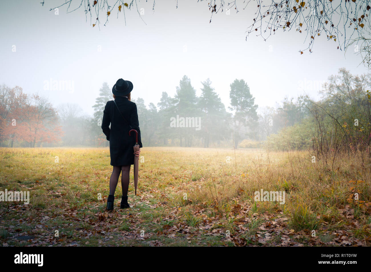 Woman in a black coat, view from the back Stock Photo - Alamy