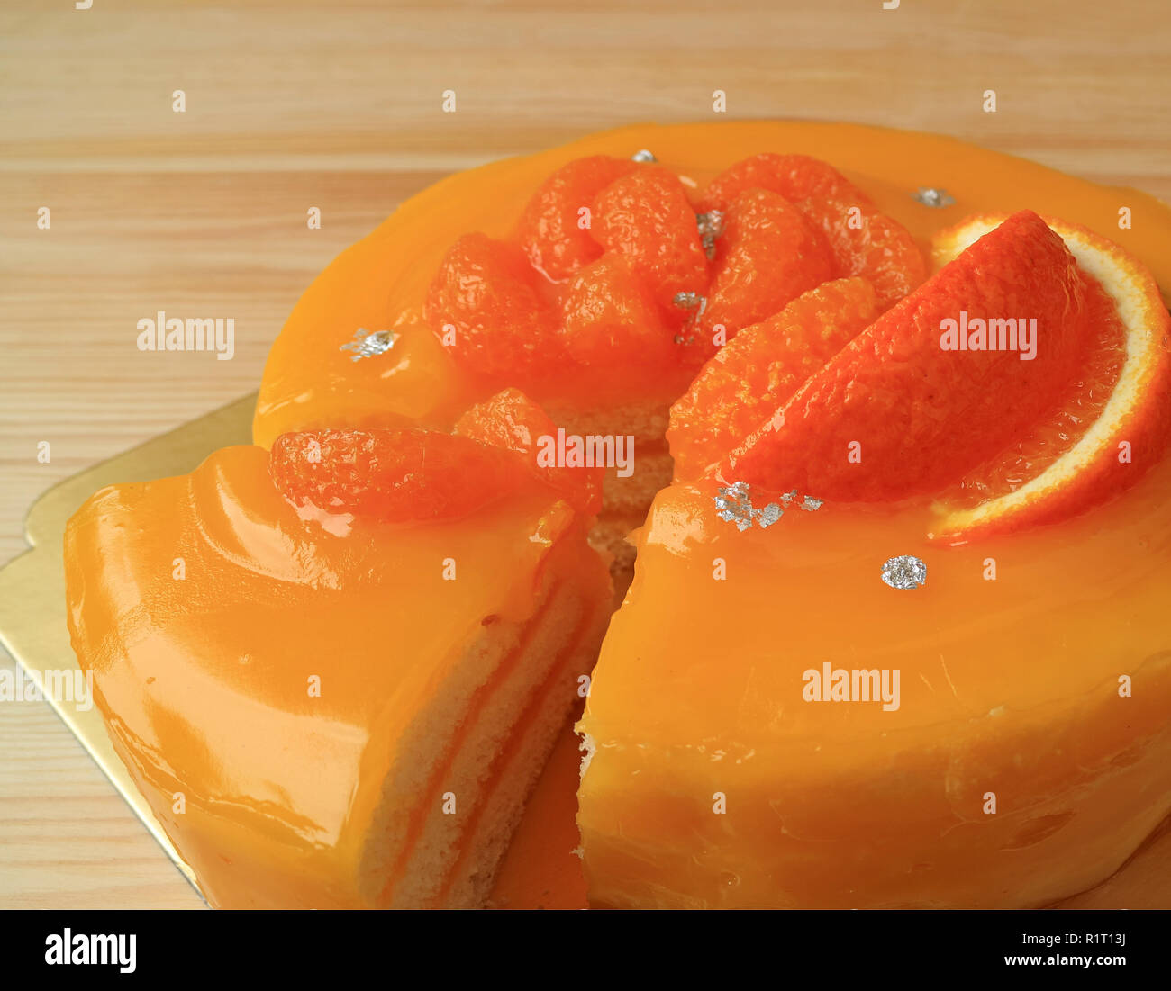 Sweet and sour mandarin orange cake with one piece cut from the whole ...