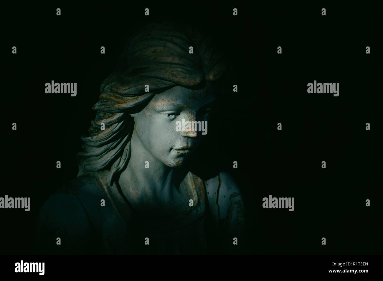 Angelic statue in spiritual light with black copy space. Low key image ...