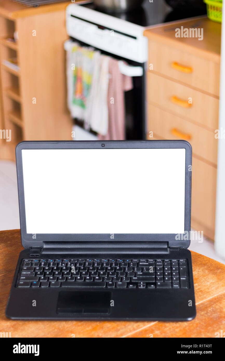 Laptop computer in vintage kitchen. Blank white screen ready for mockup ...