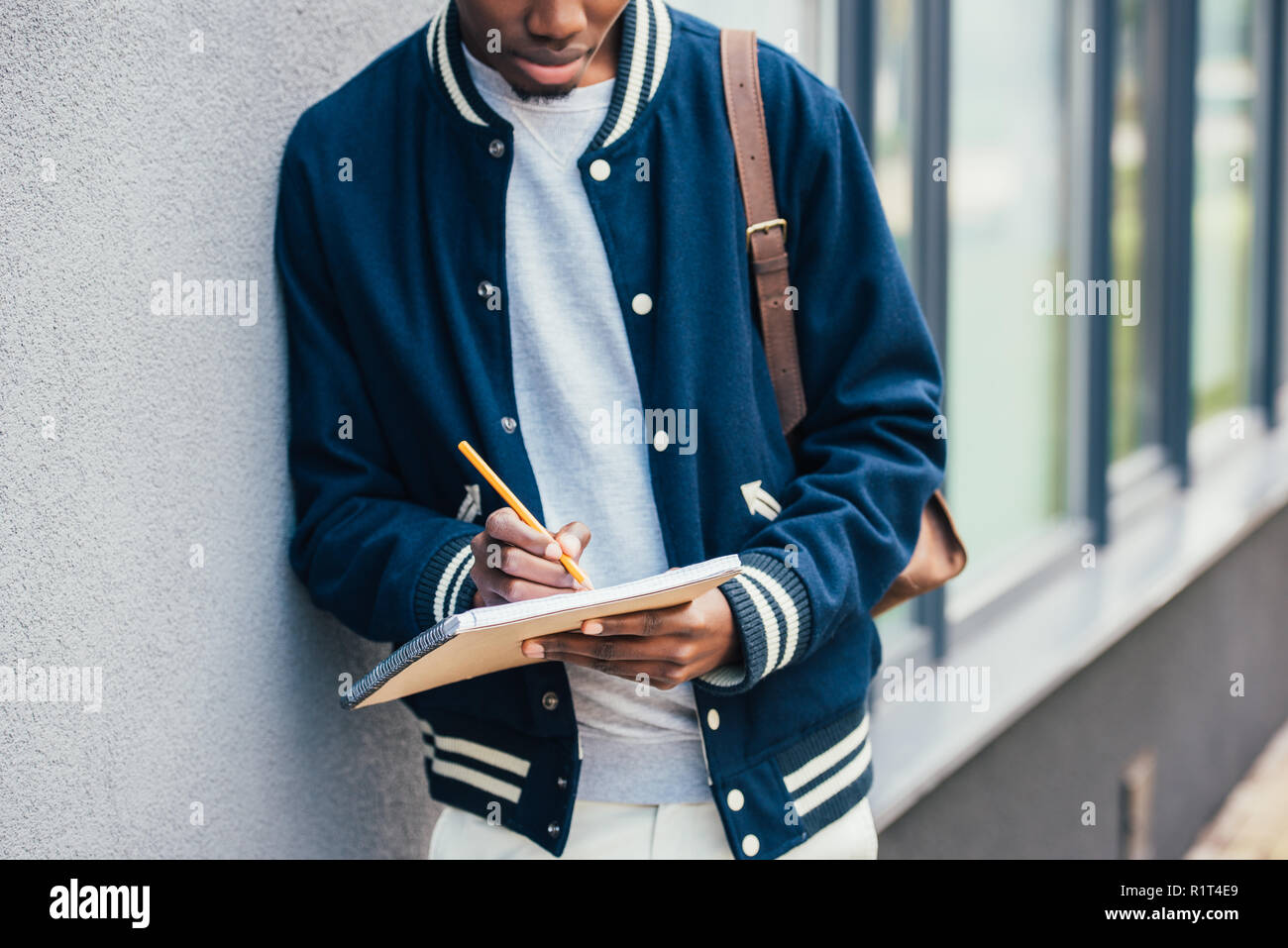 cropped view of african american student writing in textbook Stock ...